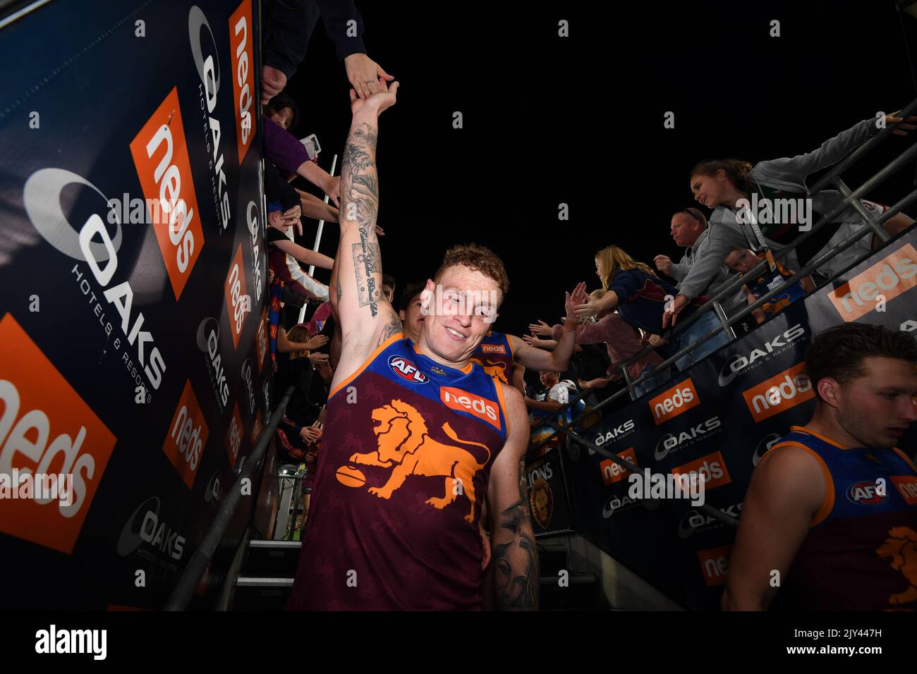 Mitch Robinson of the Lions high-fives fans after winning the Round 20 ...