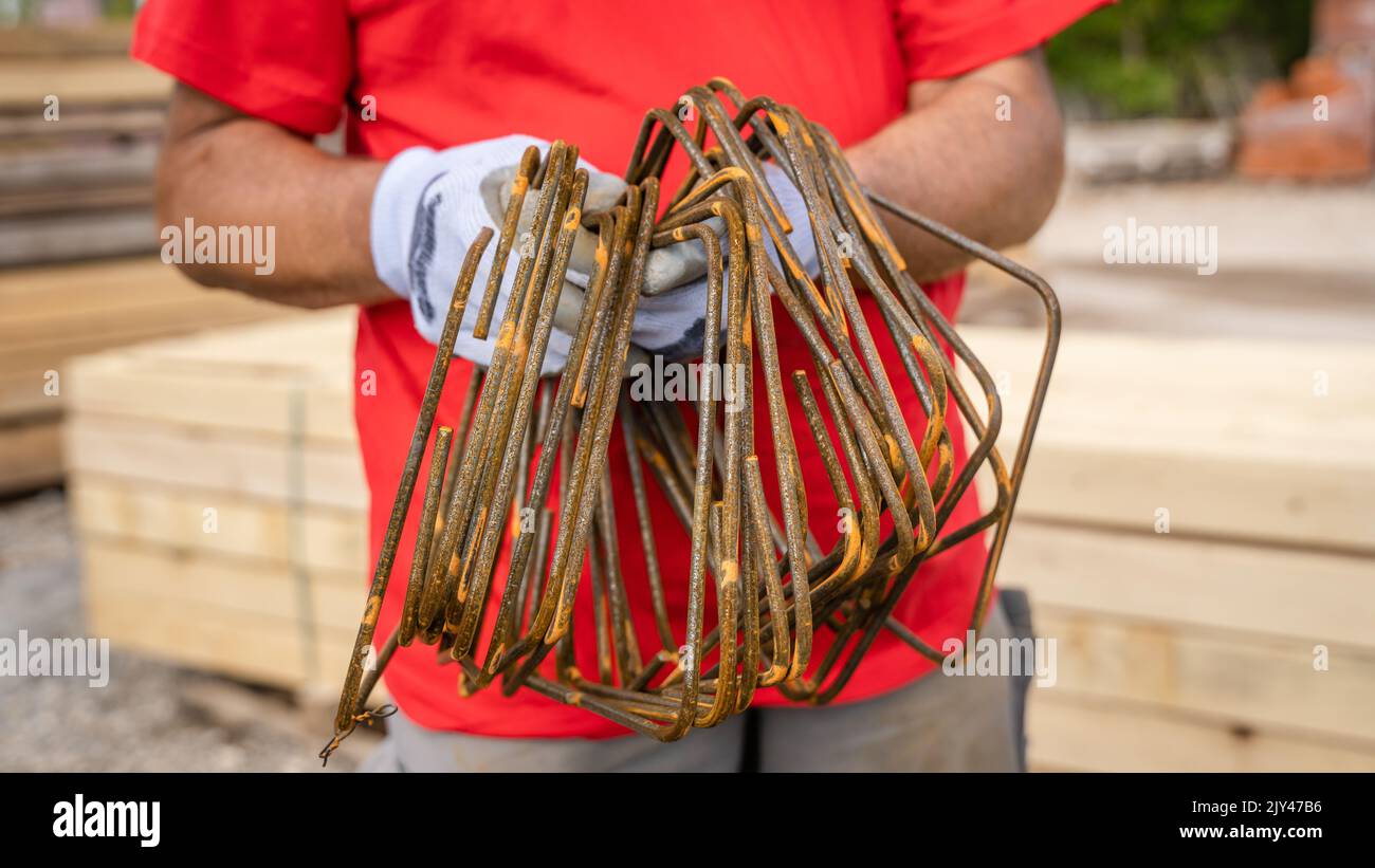 one man hold iron metal reinforcement armature at warehouse or ...