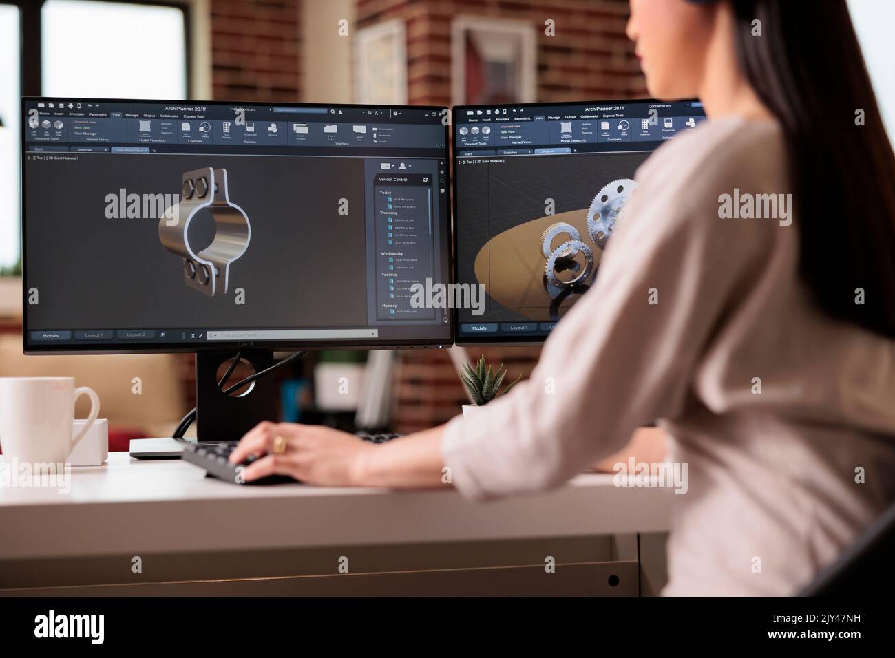 Asian developer working on gears engineering, using technical software to manufacture machine ...