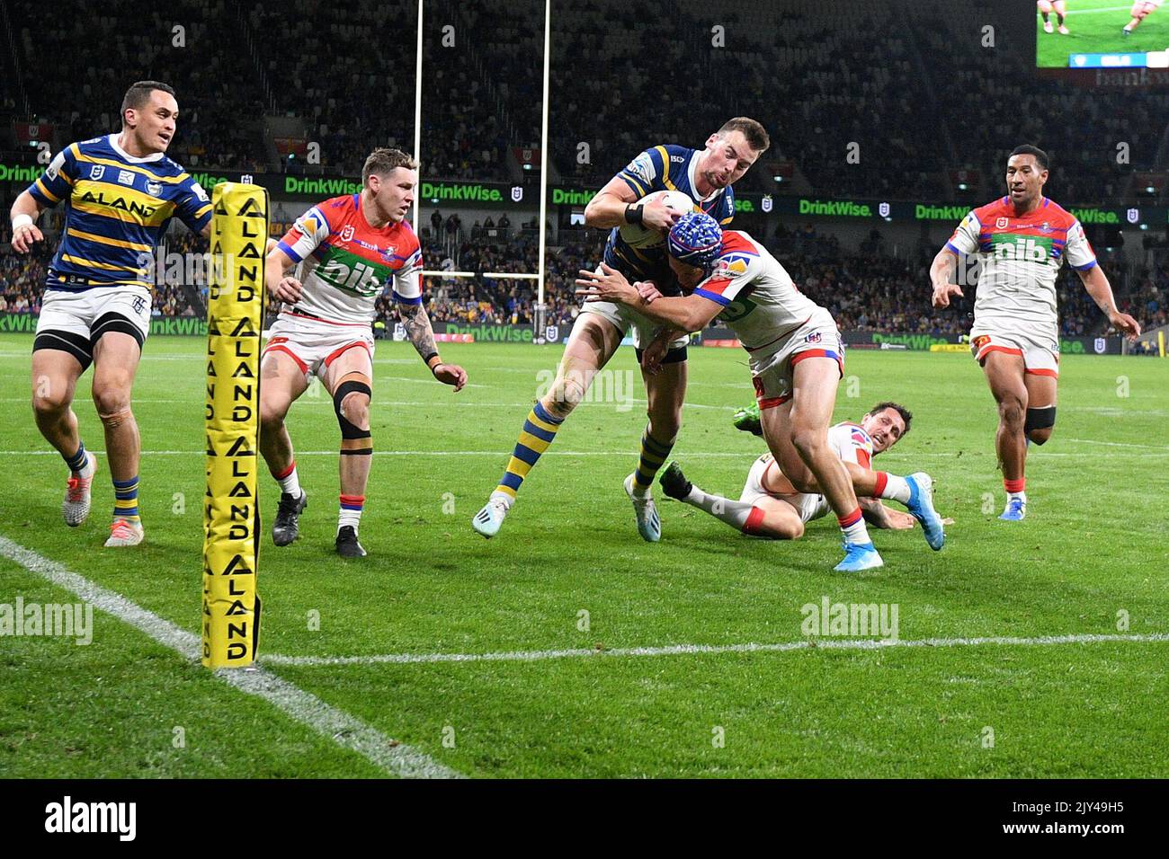 Kalyn Ponga of the Knights puts a try saving tackle on Clint Gutherson ...
