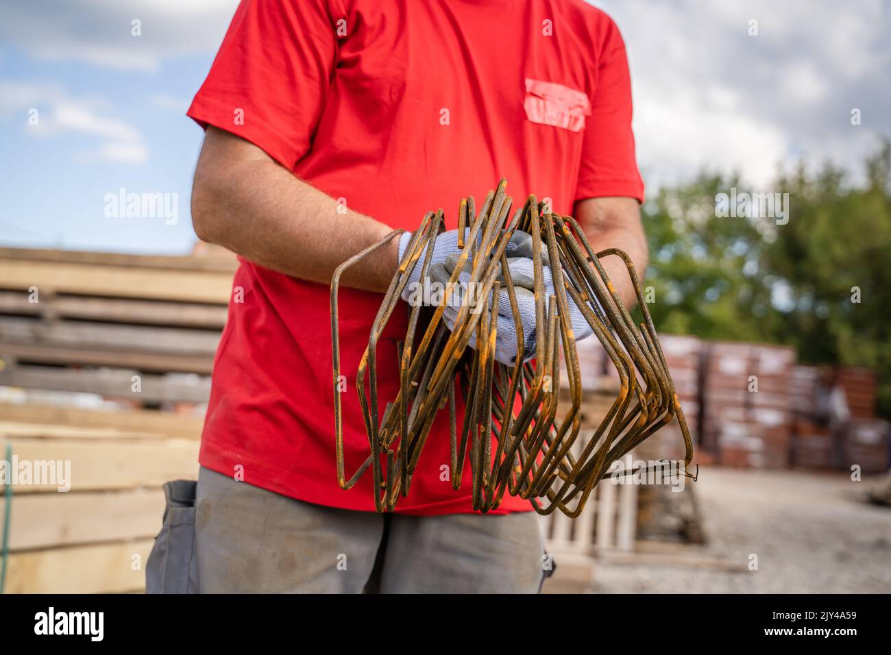 one man hold iron metal reinforcement armature at warehouse or ...