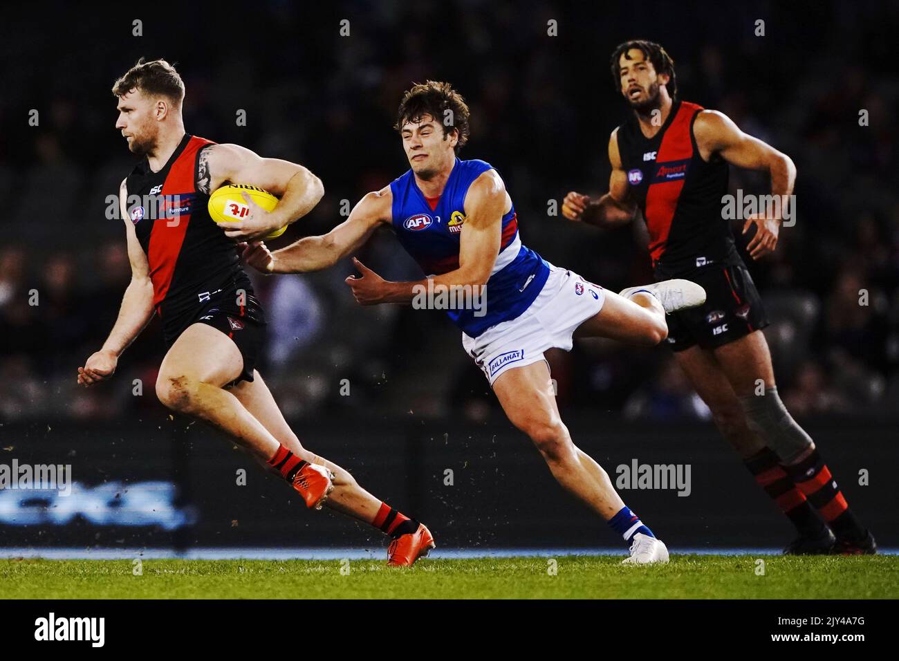 Jake Stringer of the Bombers runs with the ball ahead of Josh Dunkley ...