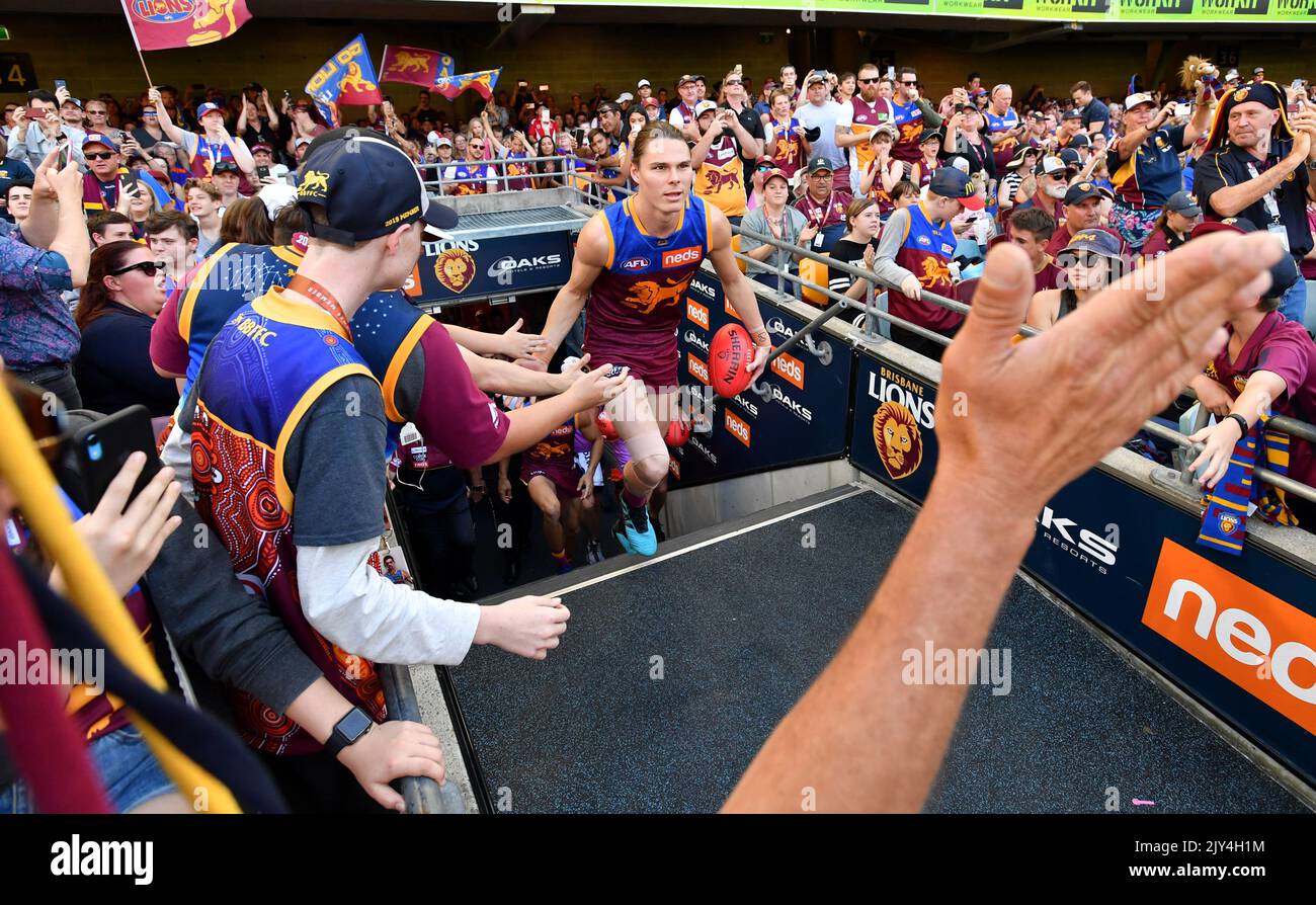 Eric Hipwood (centre) of the Lions is seen running onto the field ...