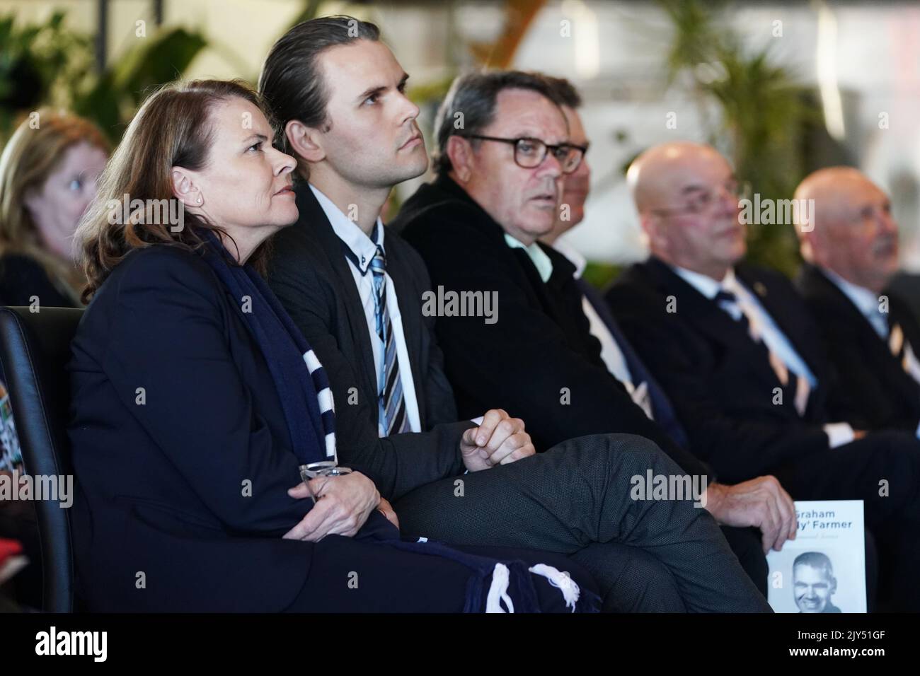 Kim Farmer listens during a memorial service for dad and Geelong ...