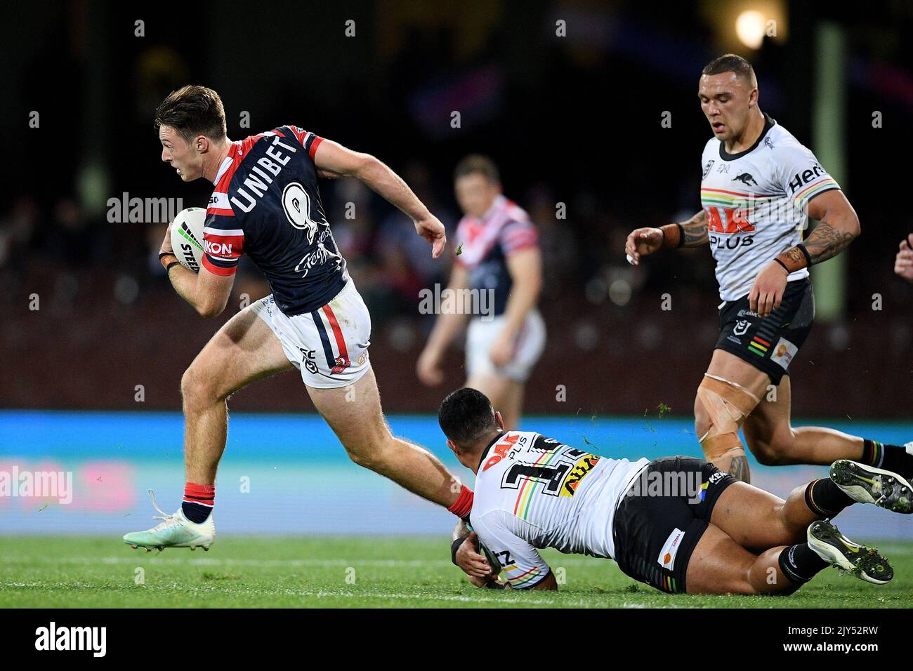 Sam Verrills of the Roosters steps through a tackle by Spencer Leniu of ...