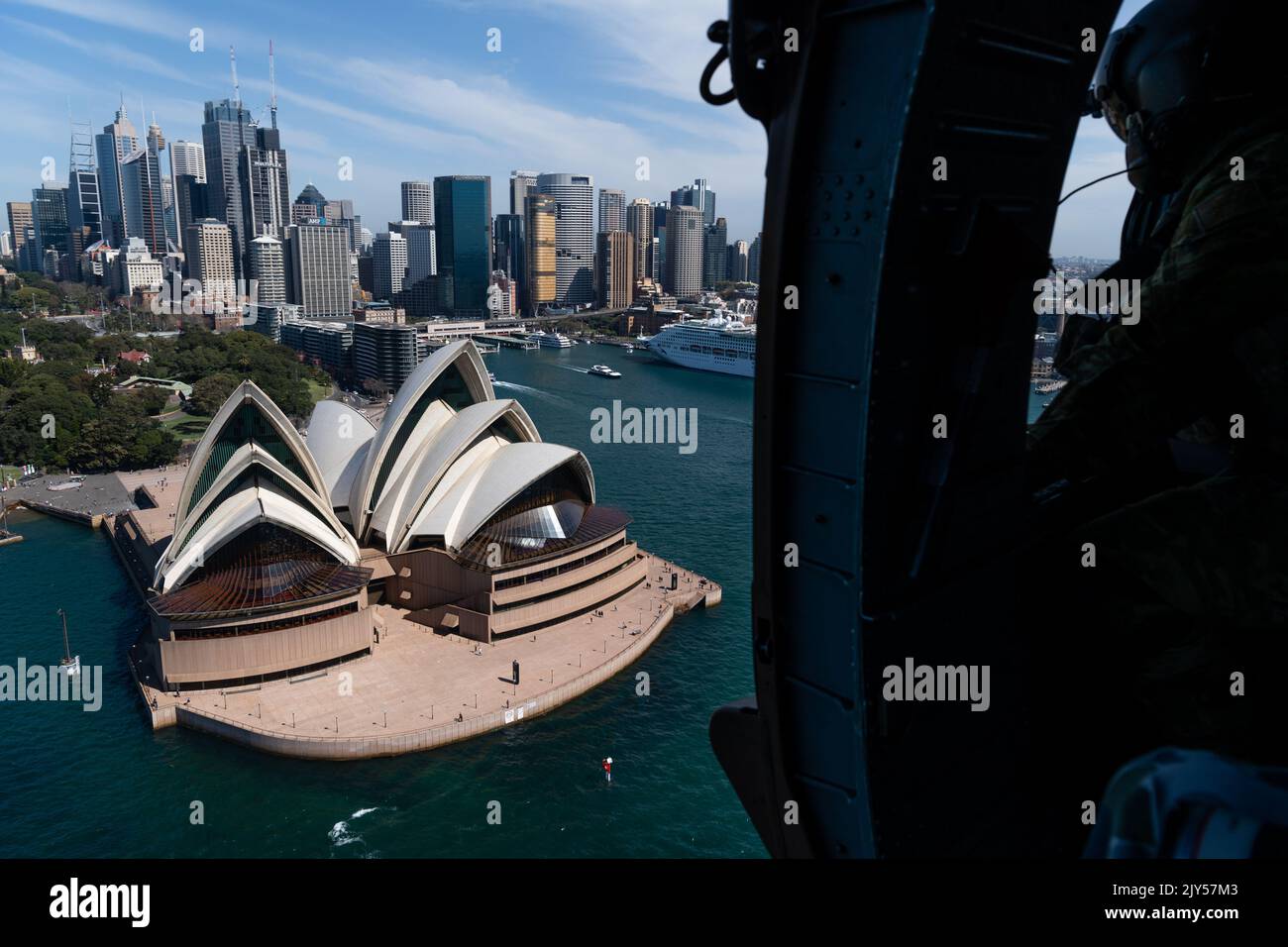 An Australian Army loadmaster looks out from an Army Black Hawk ...
