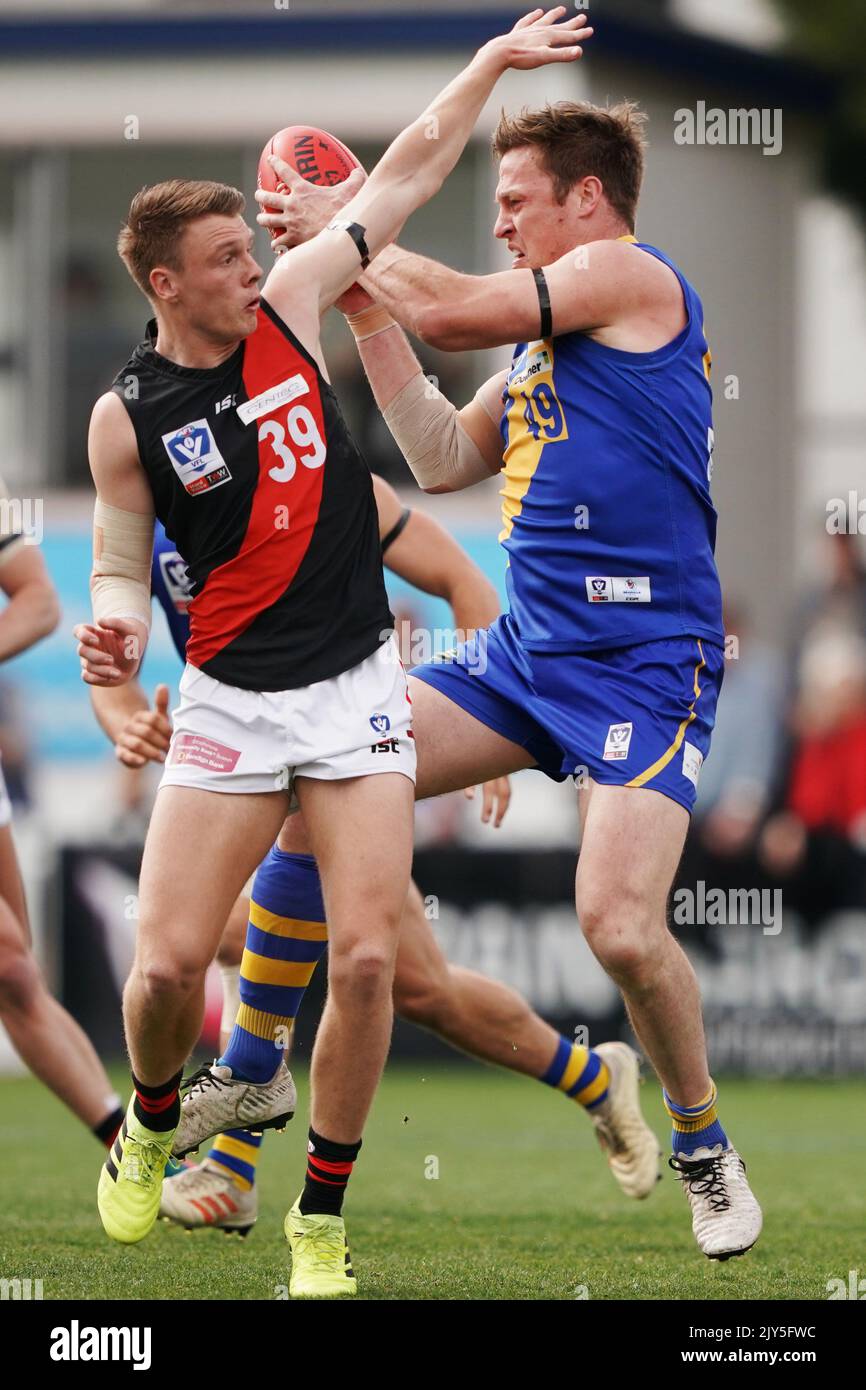 Nick Meese of Williamstown gathers the ball from Trent Mynott of ...