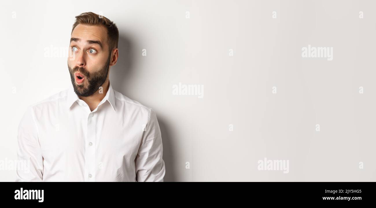 Close-up of happy and surprised man looking left with amazed face ...