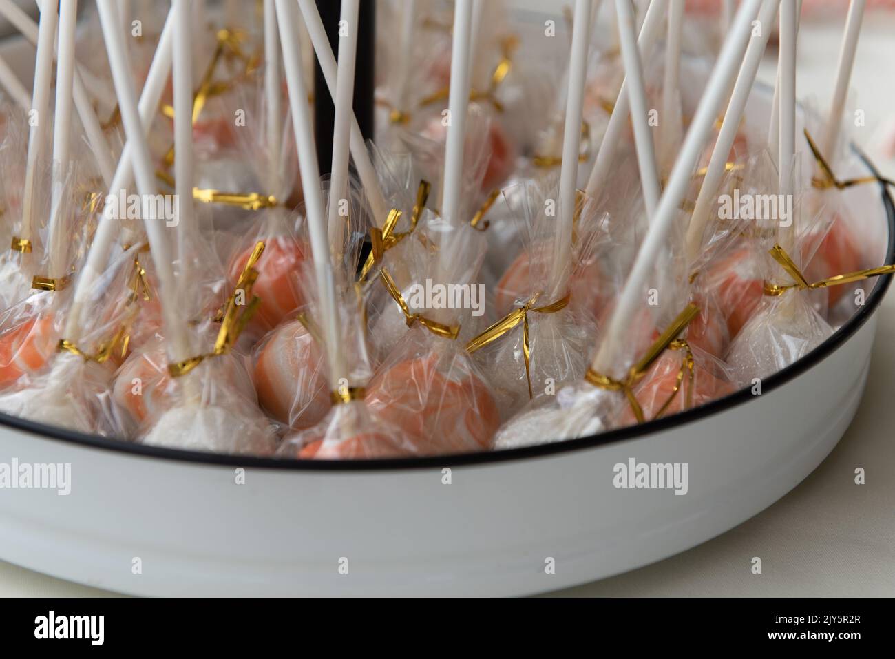 White chocolate covered cake pops are individually wrapped for party ...