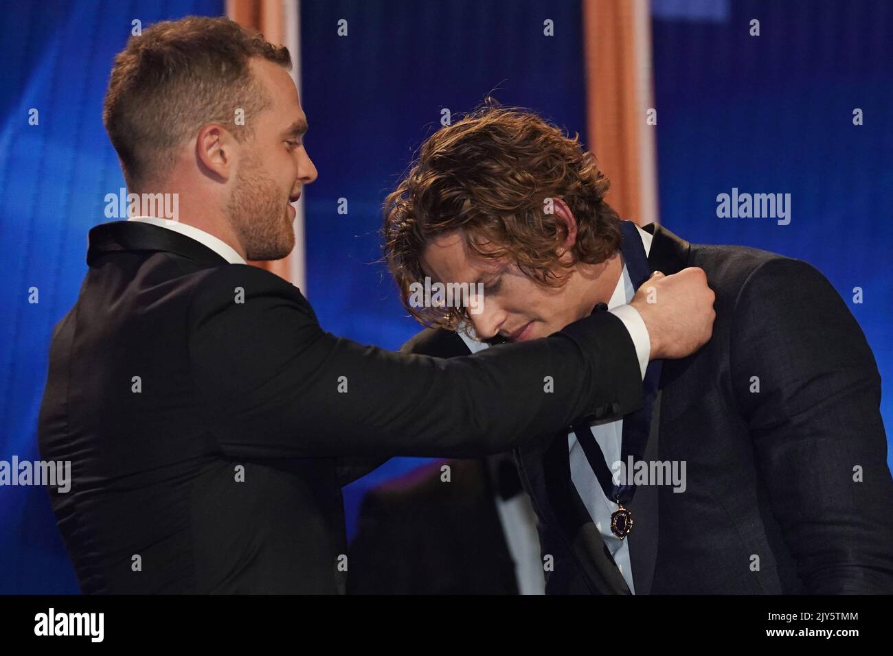 Nat Fyfe of the Dockers accepts the Brownlow Medal from Tom Mitchell of ...