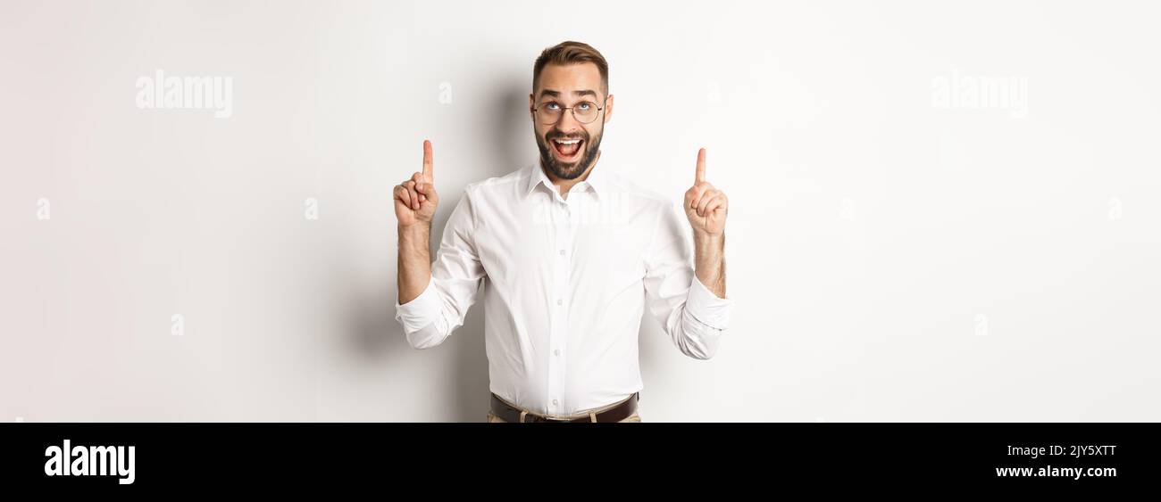 Excited businessman checking out advertisement, pointing and looking up ...