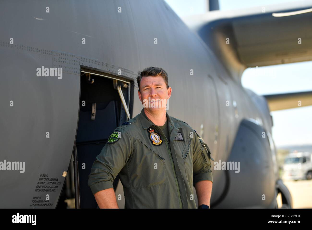 Flight lieutenant John Ayers poses for a photo with a C130 Hercules at ...