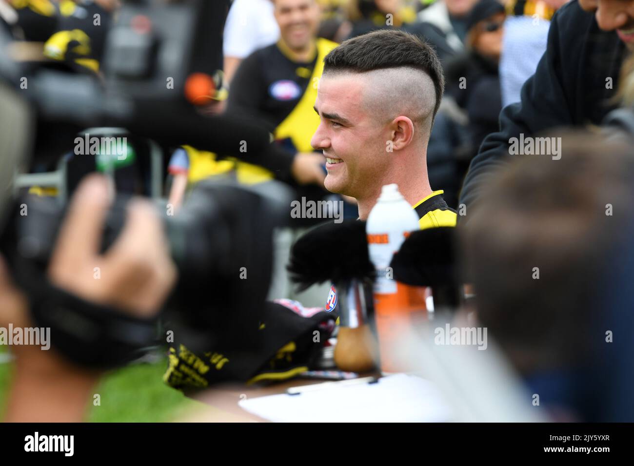 A fan is seen getting a Dustin Martin inspired haircut during the the ...