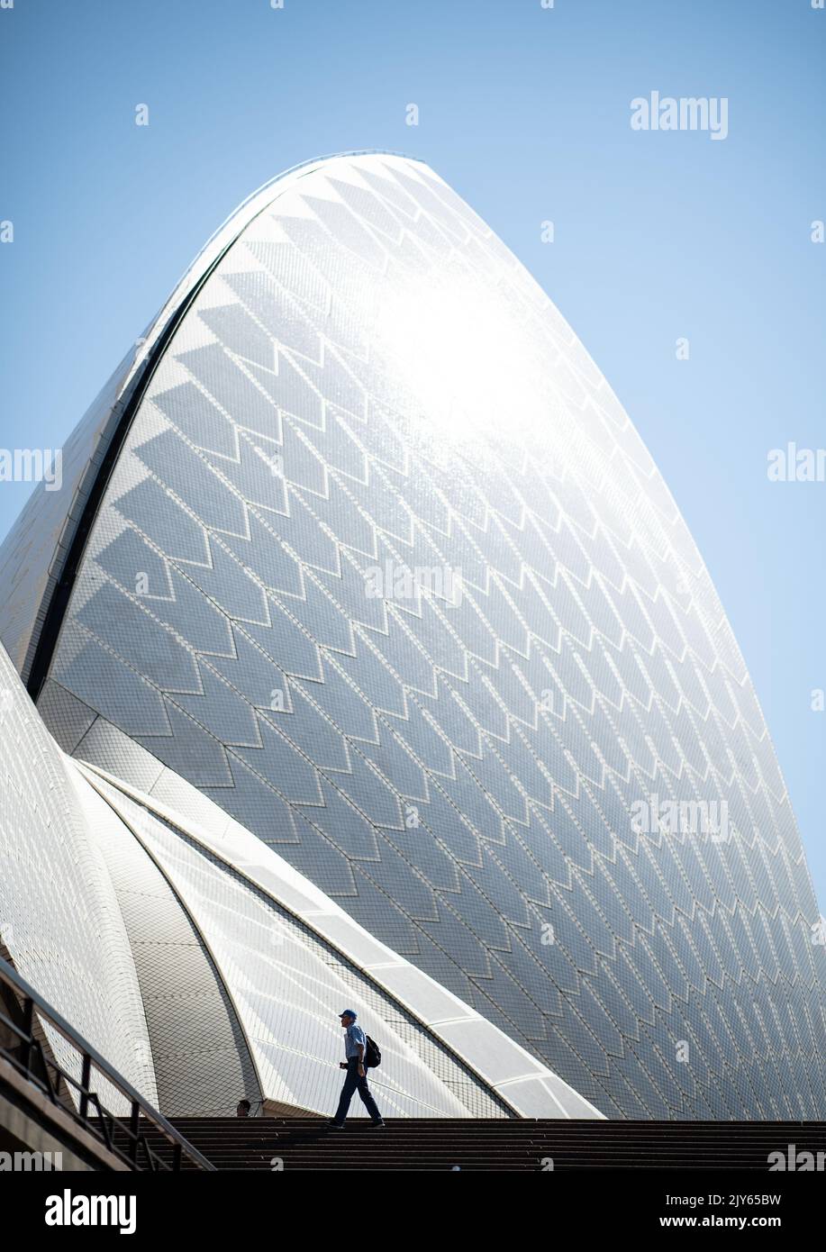 A man walks in front of the Sydney Opera House in Sydney, Wednesday ...