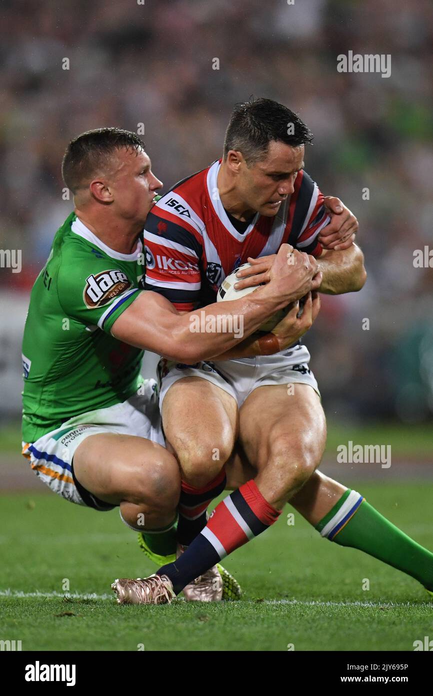 Cooper Cronk of the Roosters is tackled by Jack Wighton of the Raiders ...