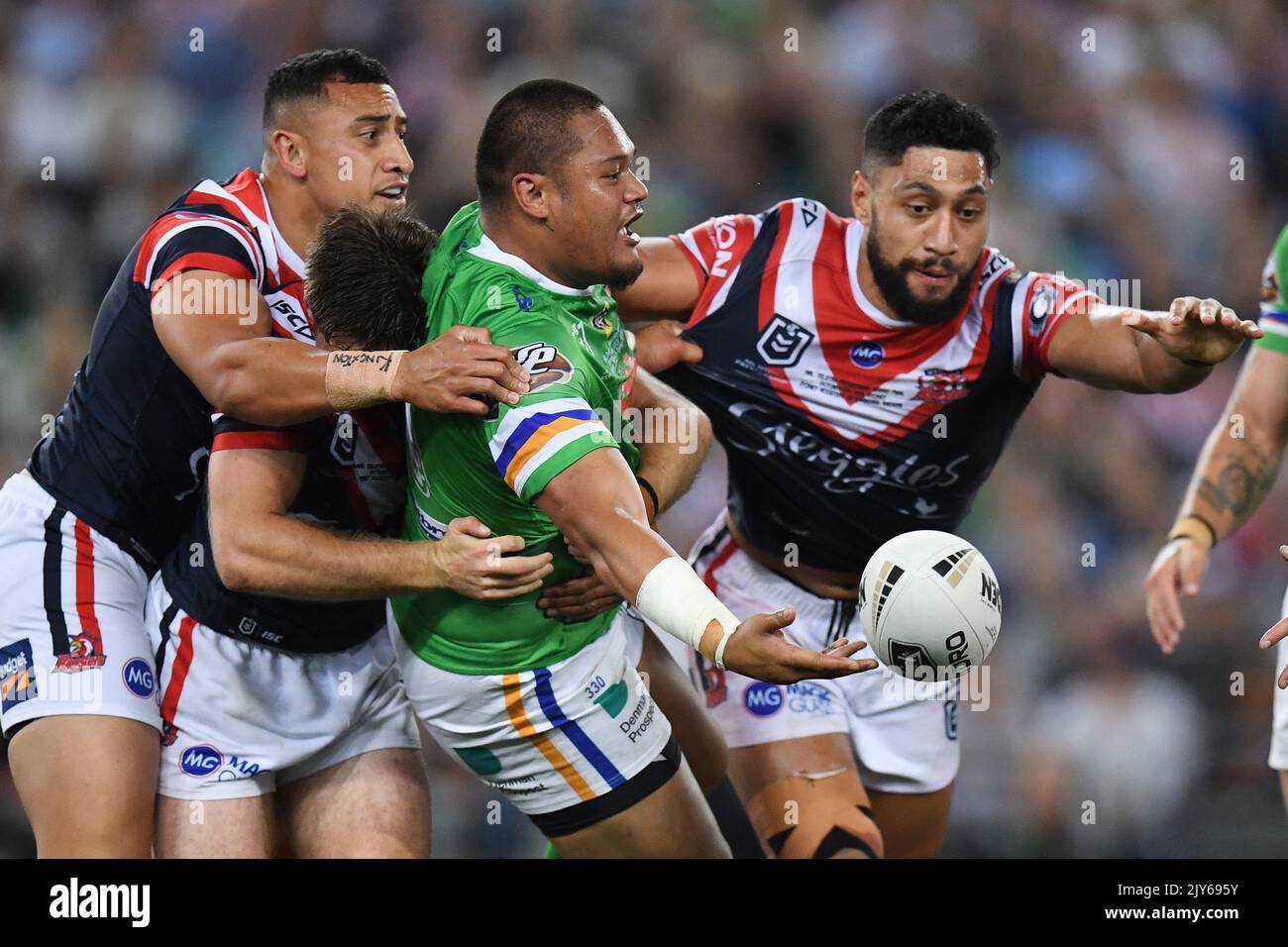 Joseph Leilua of the Raiders off loads the ball as he's tackled by ...