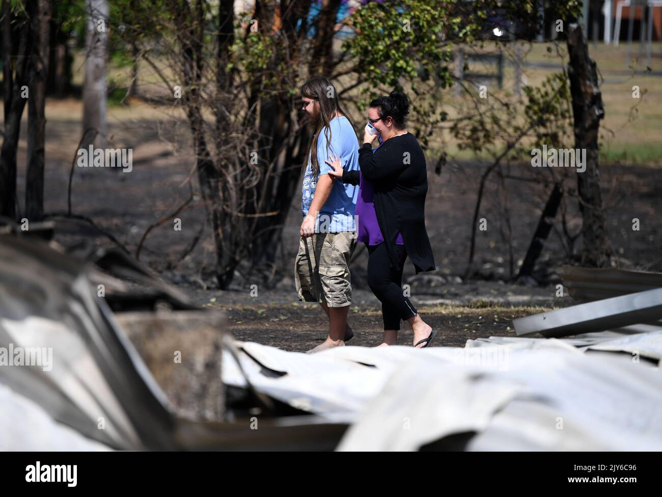 Liam McKenzie and his sister Naomi Elwell inspect the remains of his ...