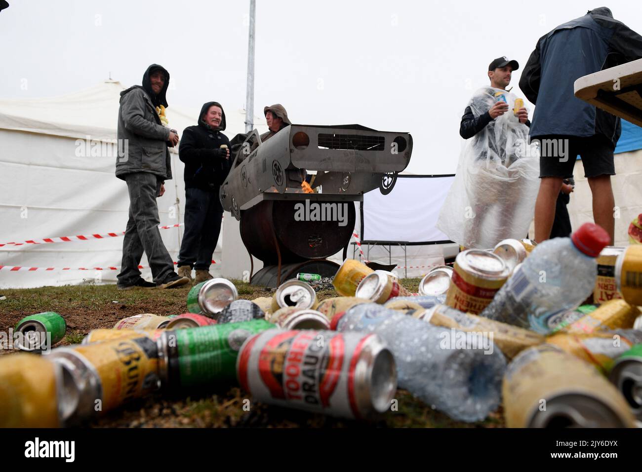 Racegoers warm up by the fire at their campsite during the 2019 ...