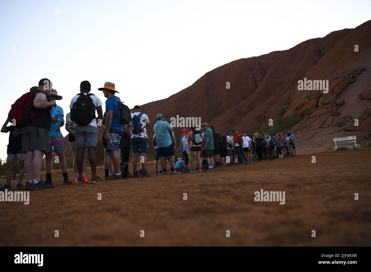 Tourists are seen lining up to climb Uluru, also known as Ayers Rock at ...
