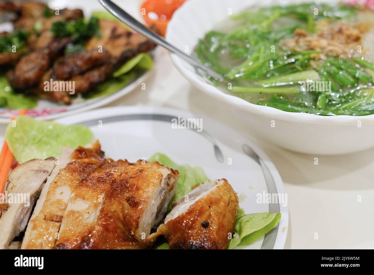 Grilled pork chop with rice noodles and crispy skin chicken with tomato ...