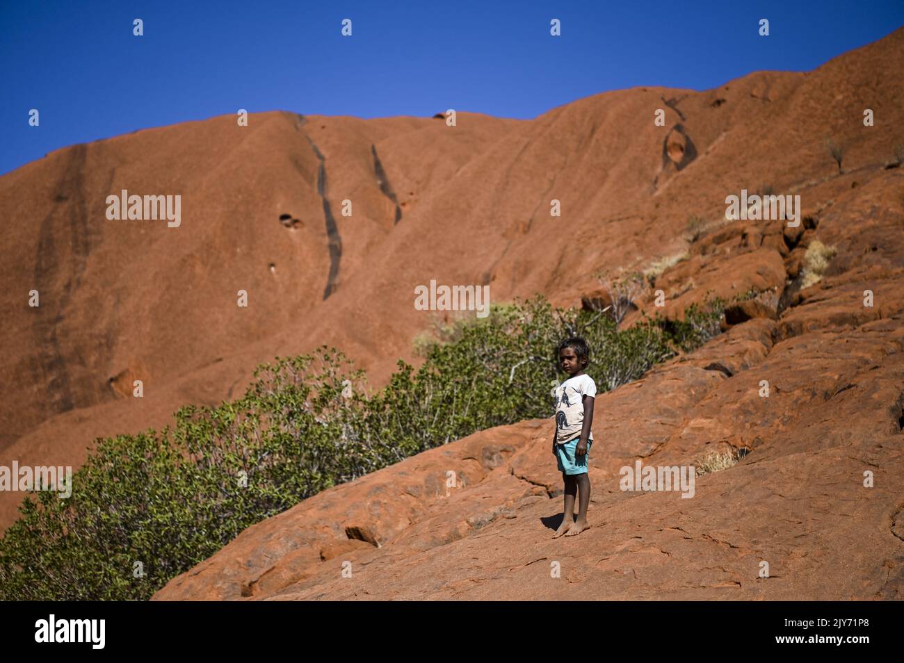 A boy plays on the bottom of Uluru ahead of the permanent closure of ...