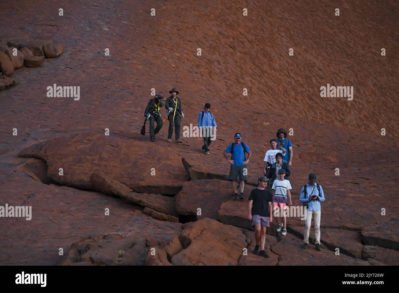 A group of eight tourists to last ascent Uluru is seen climbing at ...