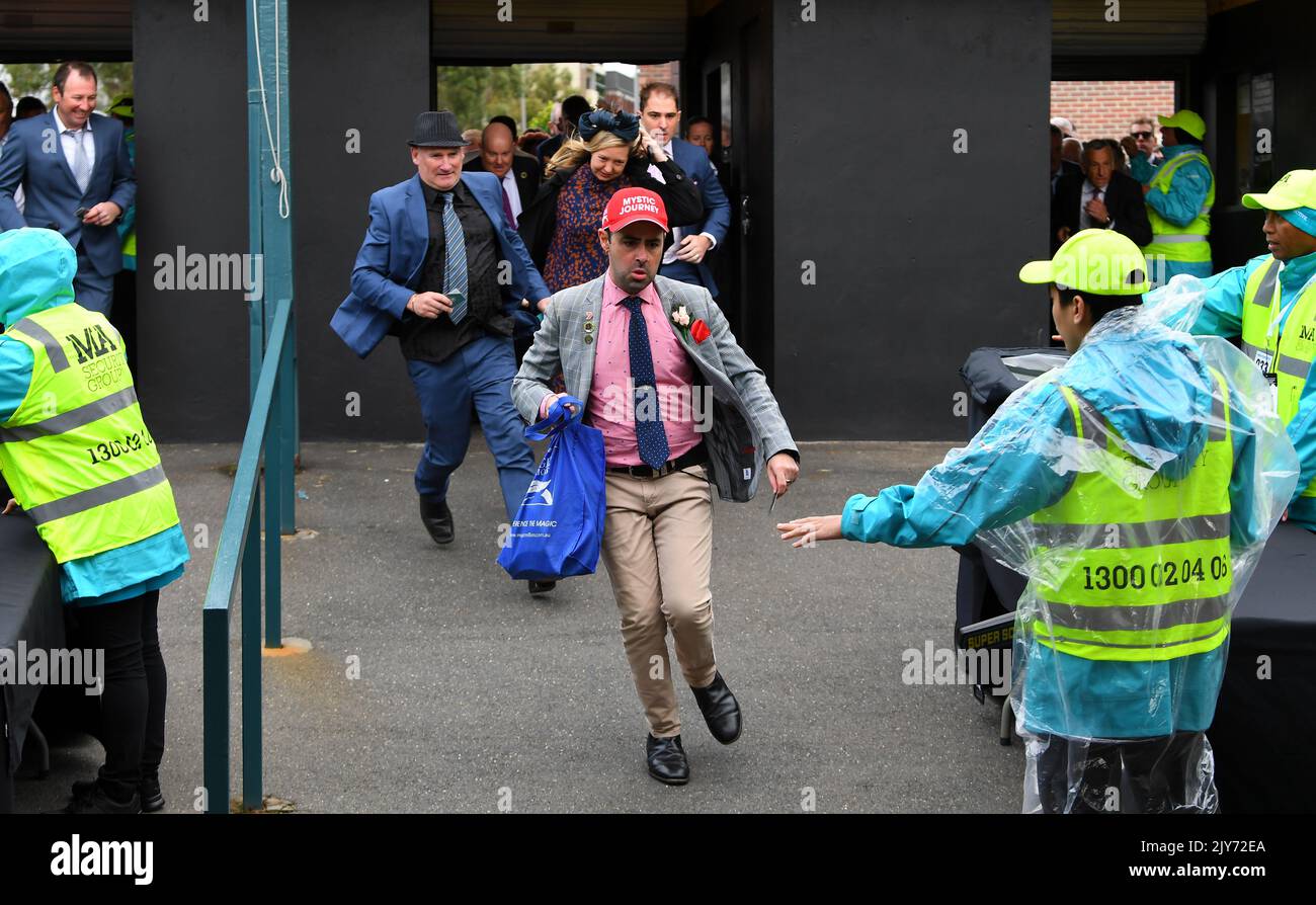 Racers race through the turnstyles as the gates open during Cox Plate ...