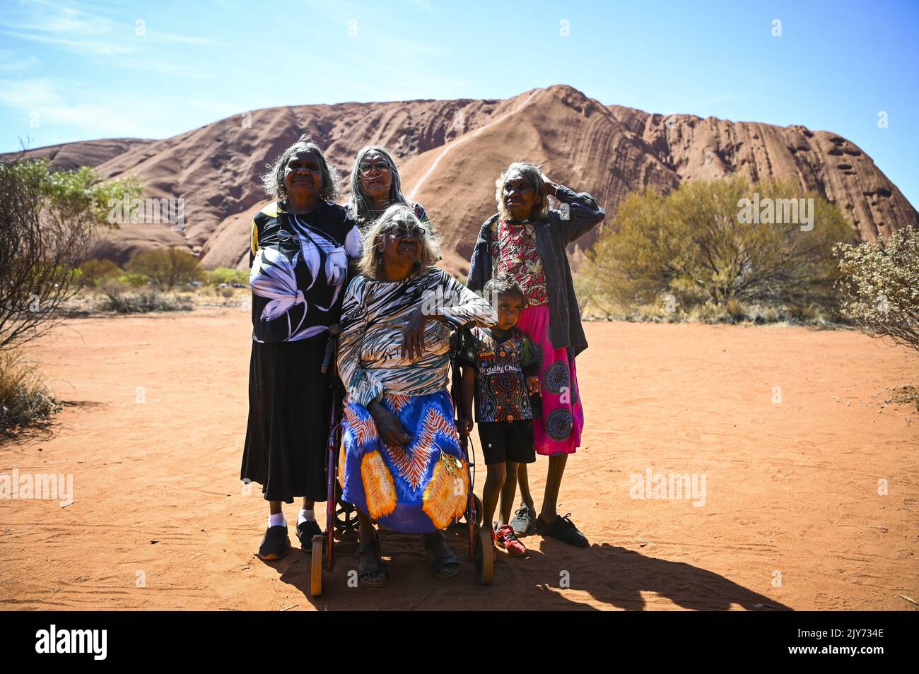 Traditional owners pose for photographs in front of Uluru, also known ...