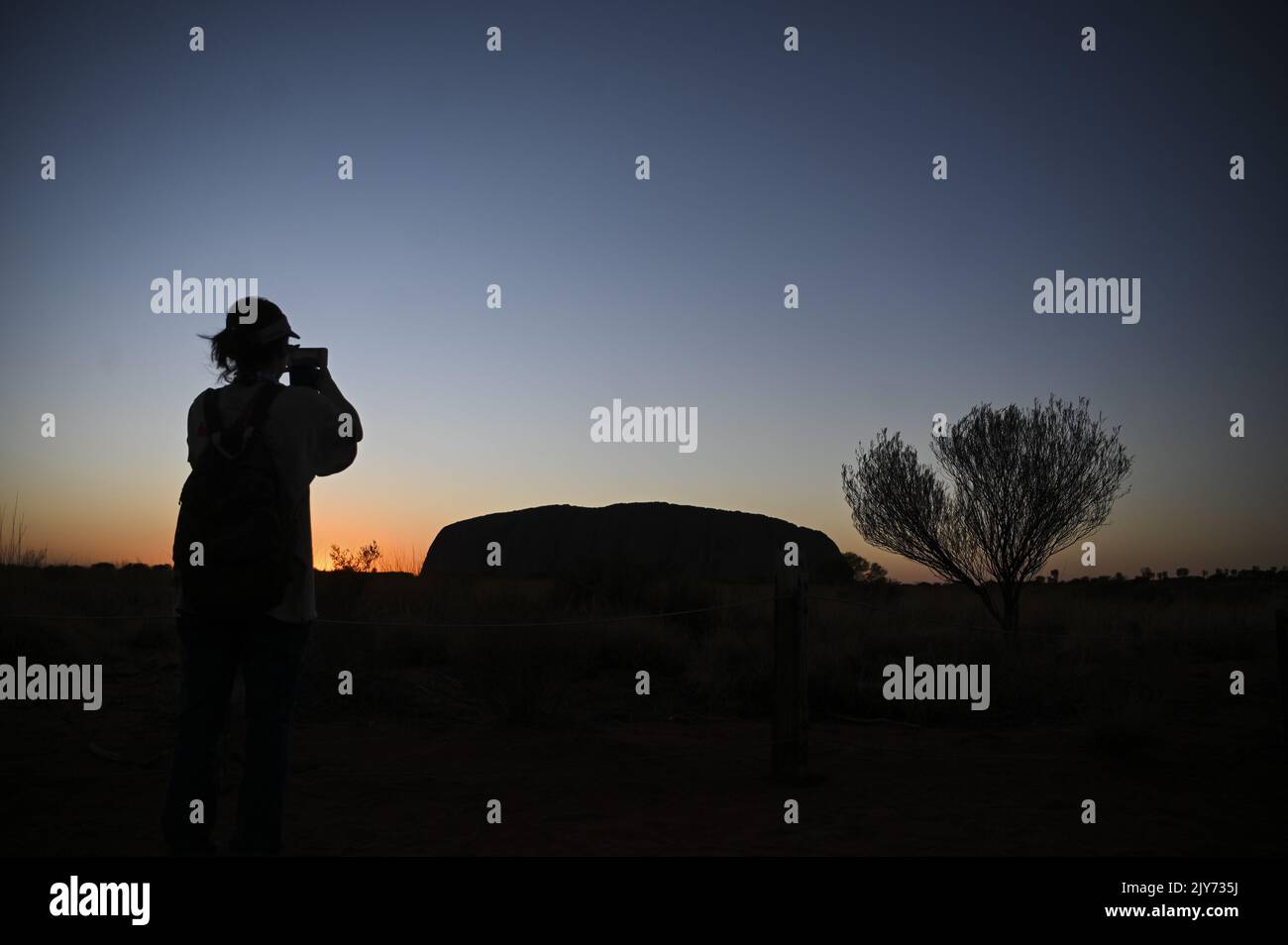 Tourists take pictures of Uluru, also known as Ayers Rock during ...