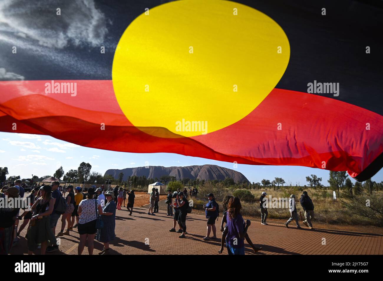 Uluru, also known as Ayers Rock is seen under the Aboriginal flag as ...