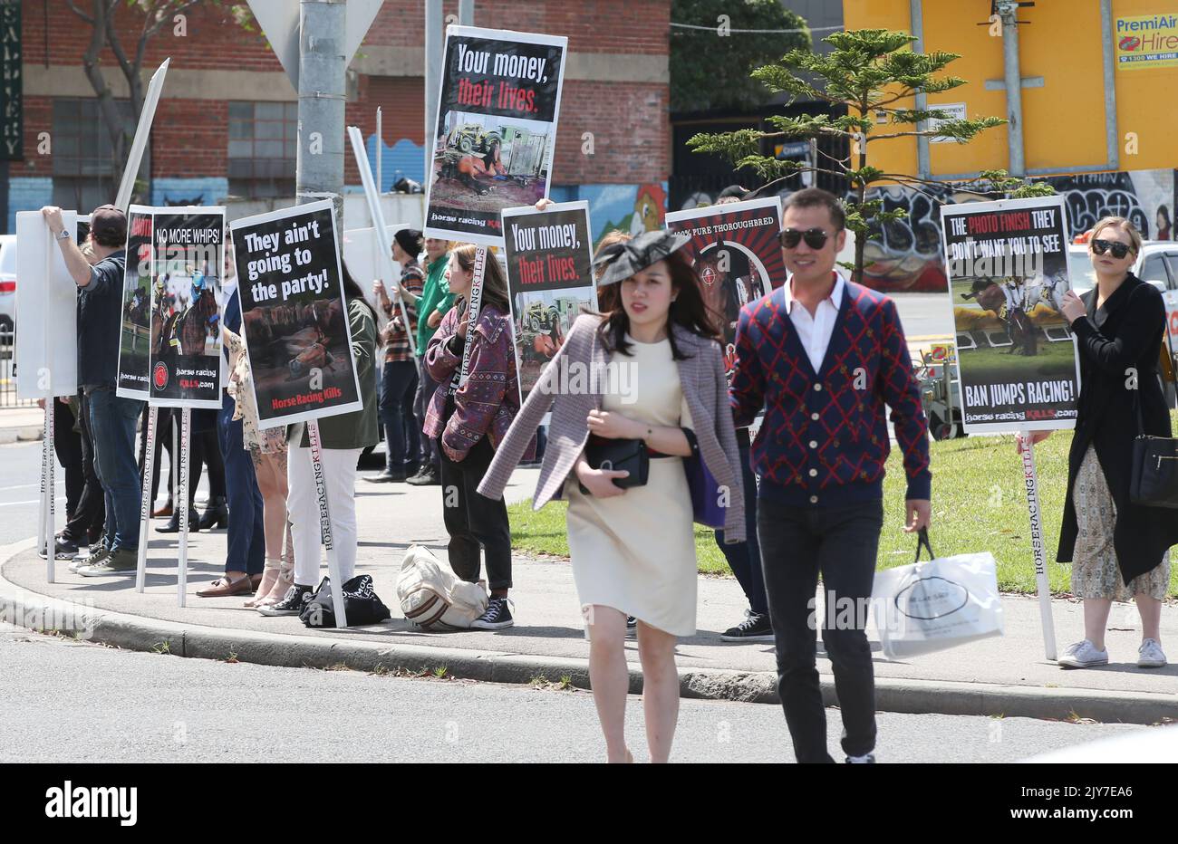 Racegoers go past Animal activists who are staging a protest during ...