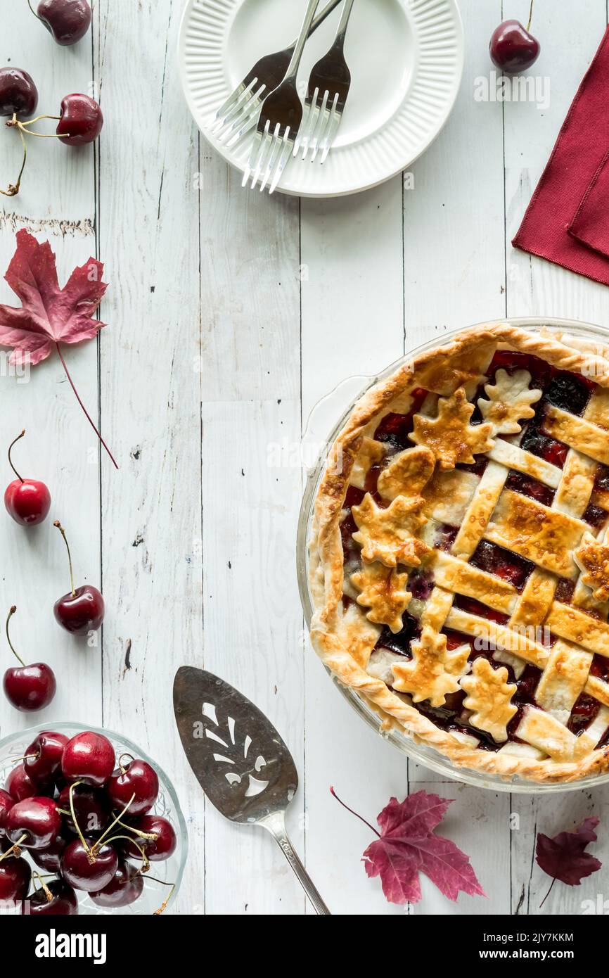 Top down view of a fall themed cherry pie with copy space to the left ...
