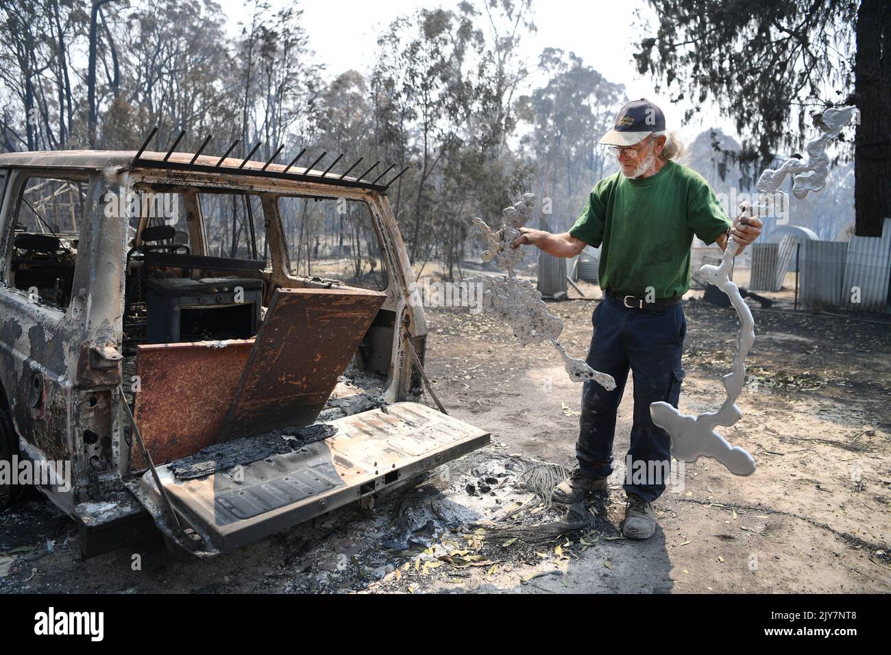 Thomas Eveans holds melted aluminium as he inspects the remains of his ...