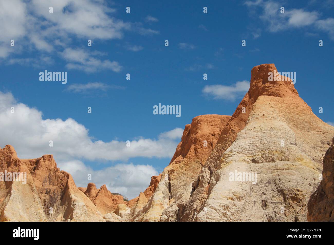 Crag of colored sand and white clouds in a blue sky. Typical brazilian ...