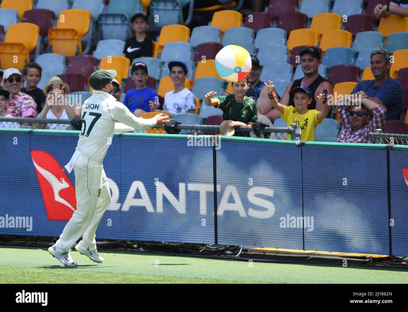 Australian bowler Nathan Lyon returns a ball to spectators on day four ...