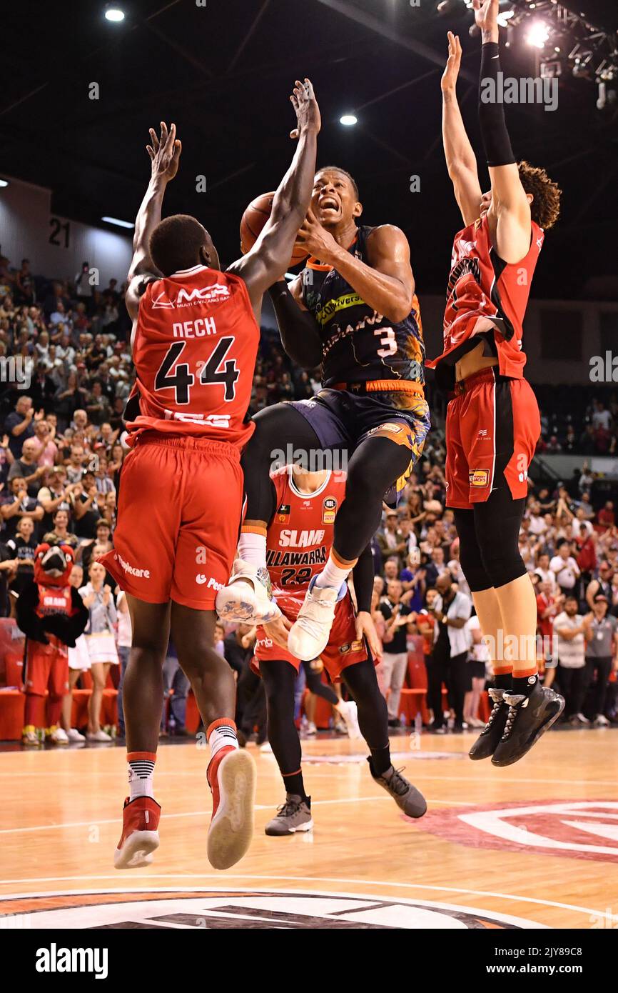 Scott Machado of the Taipans is prevented from scoring by Sunday Dech ...