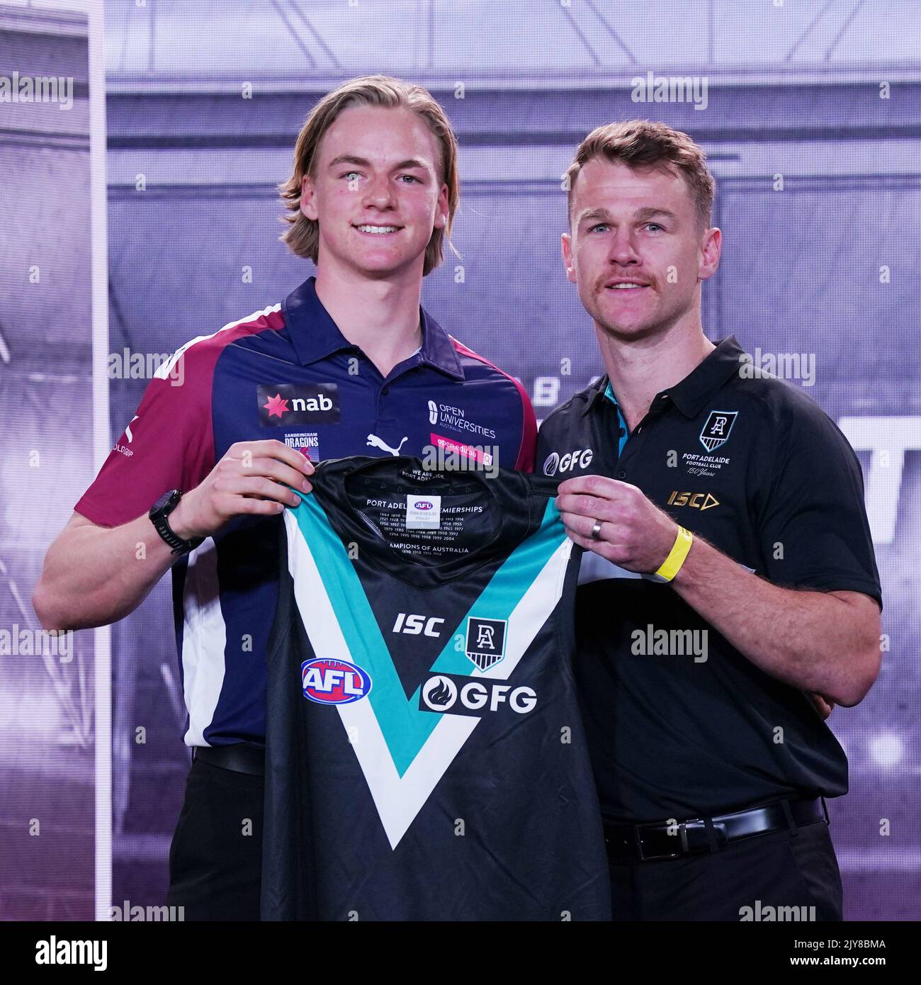 Miles Bergman (left) is presented with a jersey by Robbie Gray of the ...