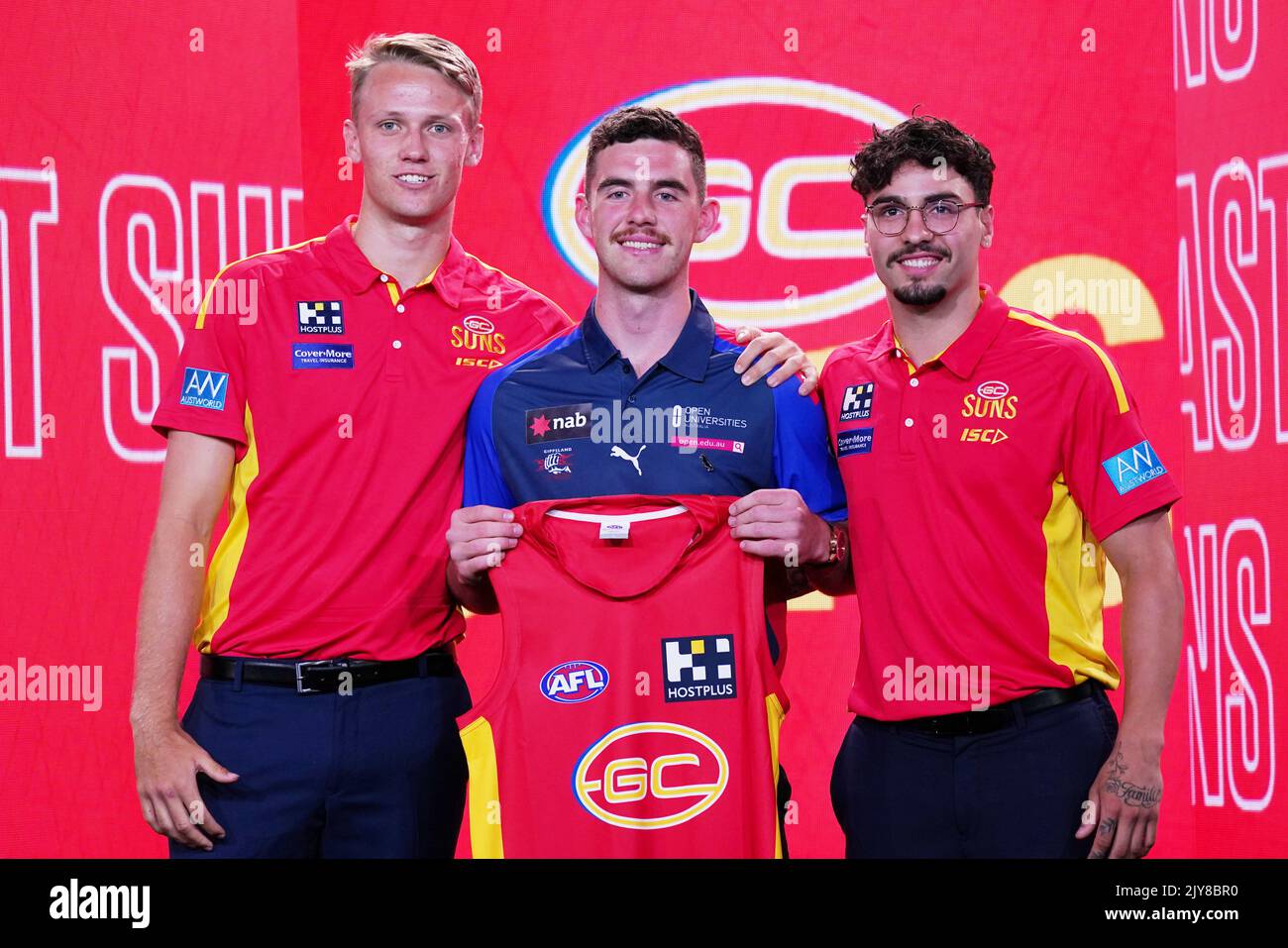 Sam Flanders is presented with a jersey by Jack Lukosius (left) and ...