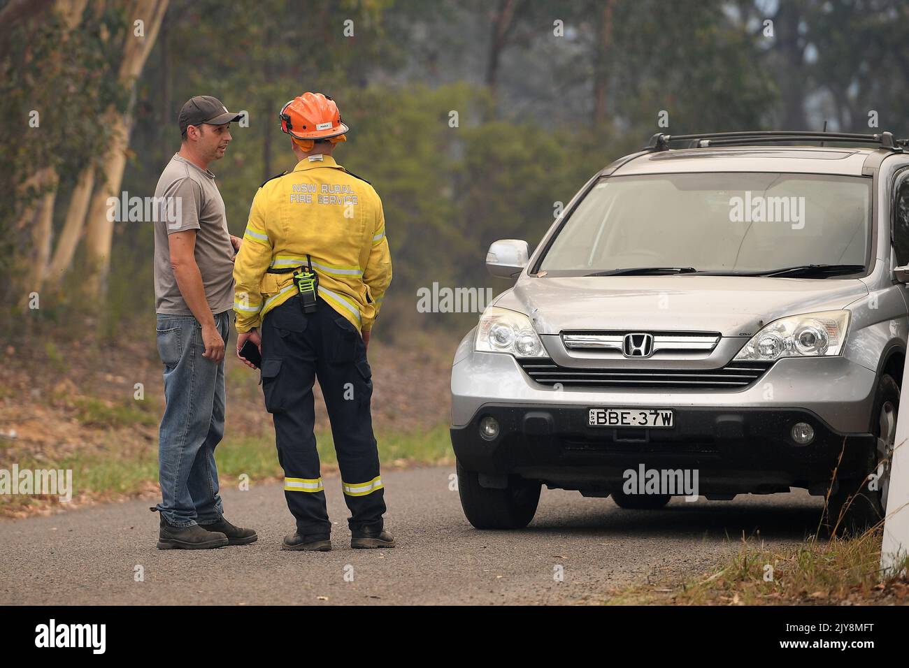 A resident speaks with a Rural Fire Service firefighter as ember ...