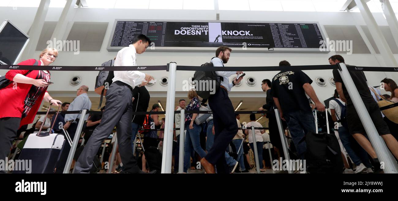 Passengers queue at security check points following a system fault at ...