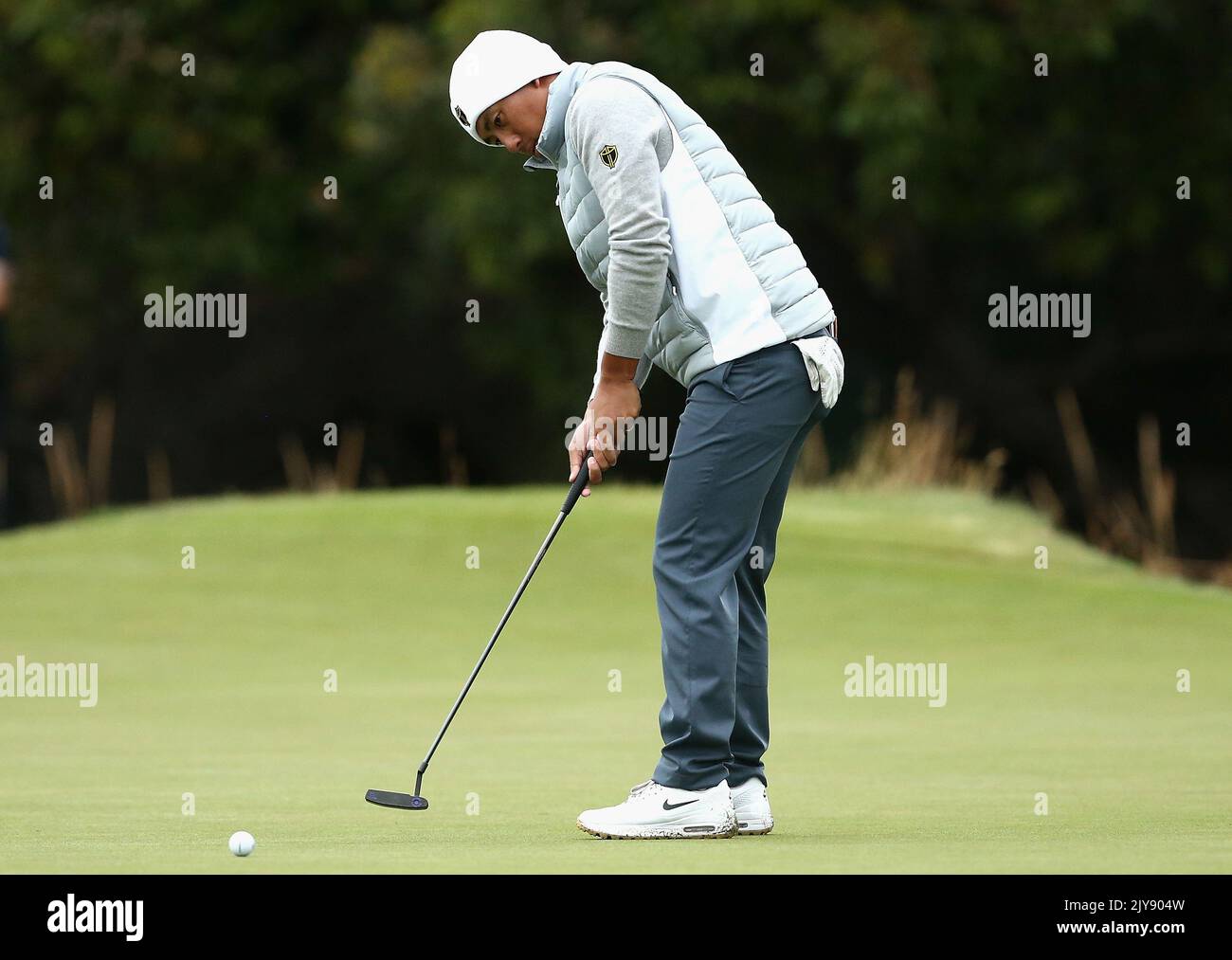 C.T. Pan of Taiwan and the International team plays a shot on the first ...