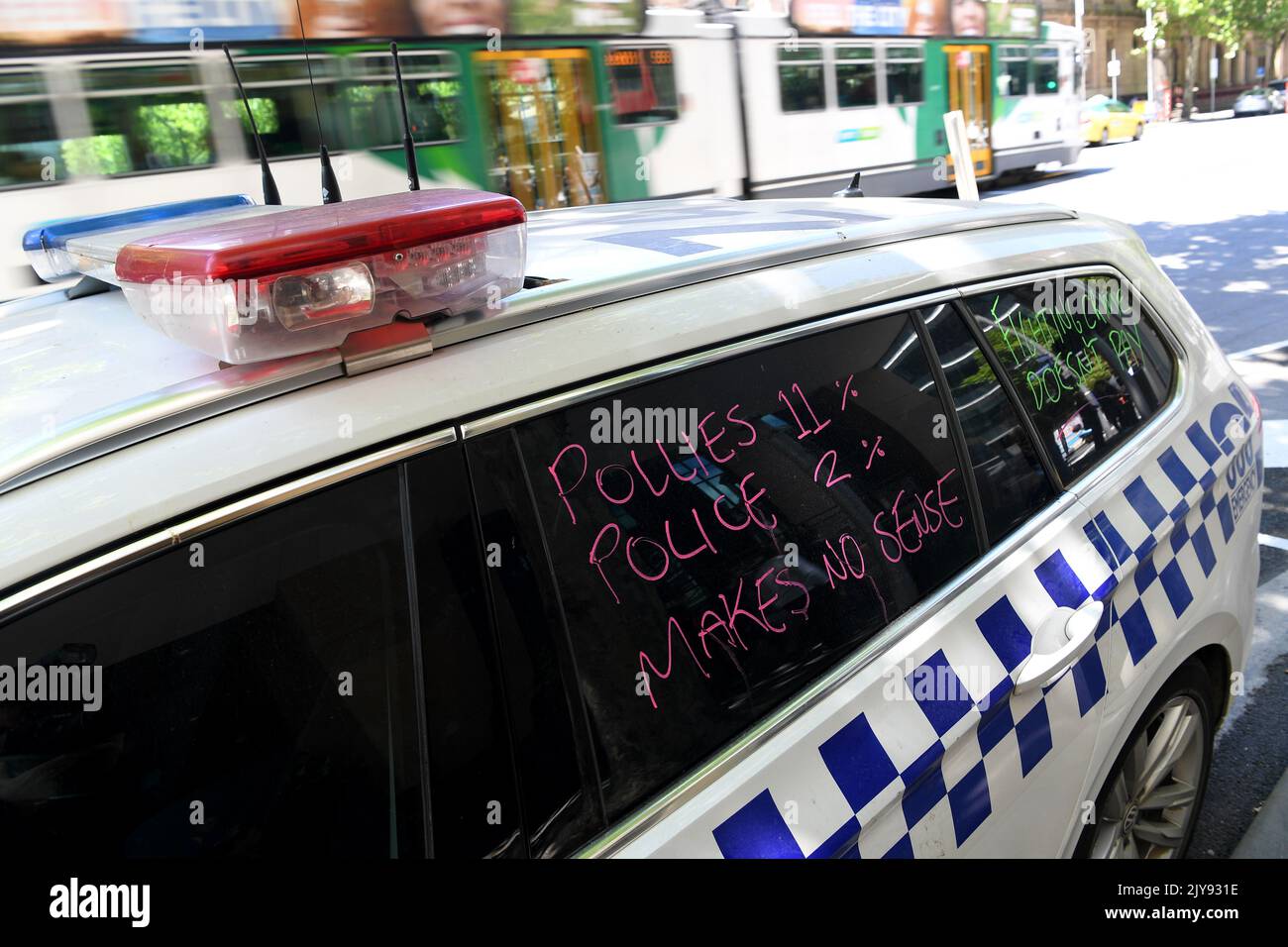General view of a Victoria Police car with slogans written in chalk ...