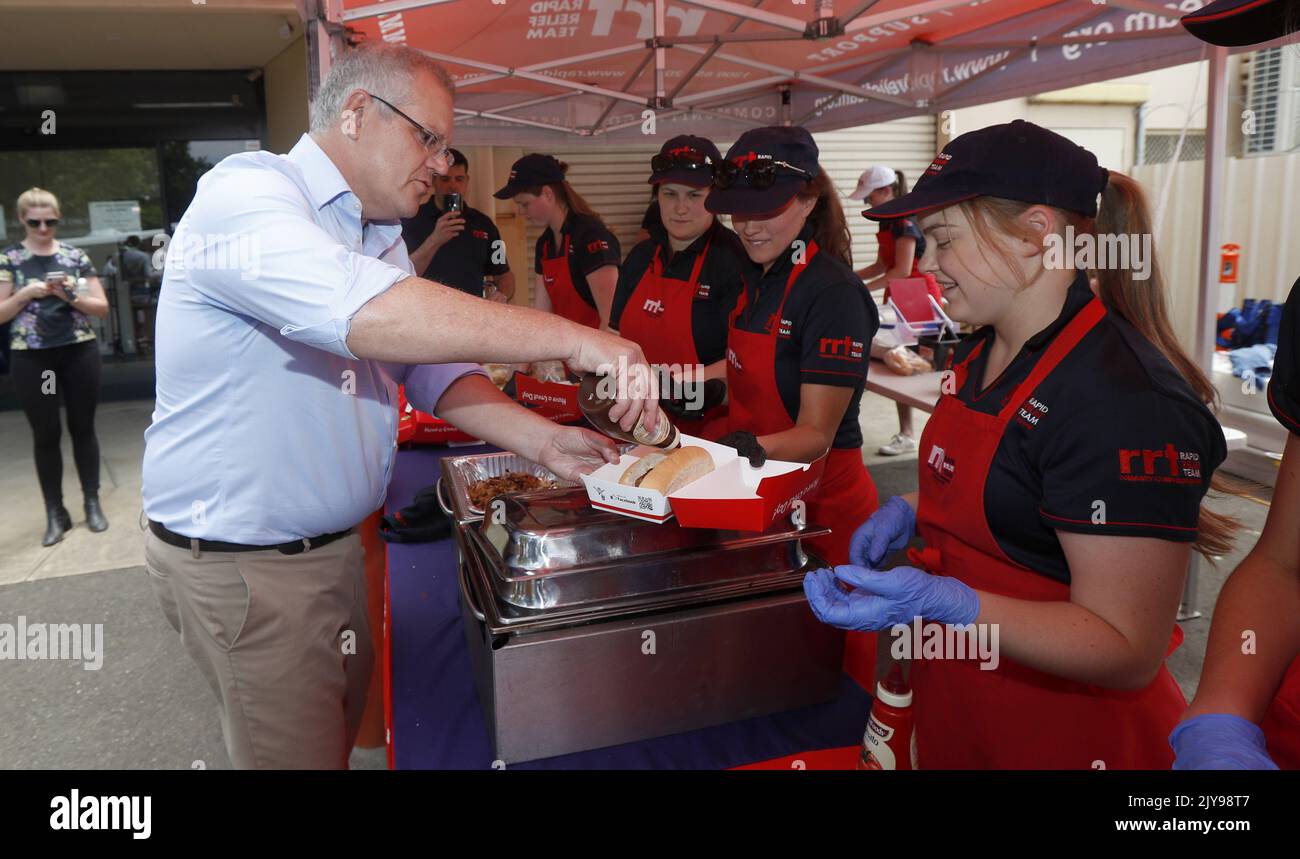 Prime Minister Scott Morrison gets a sausage sandwich after visiting ...