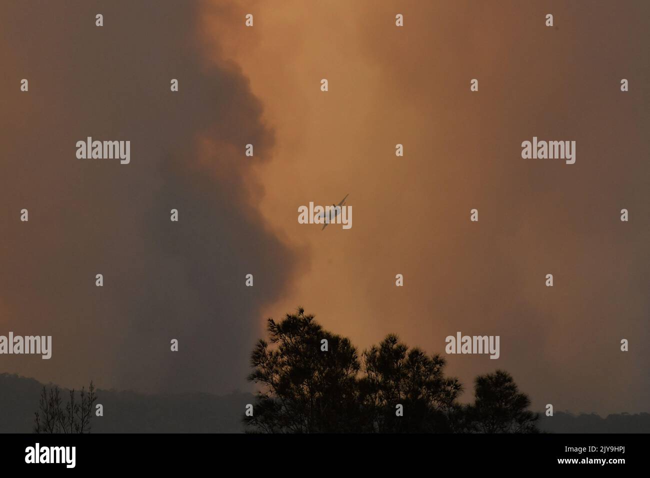 A DC-10 Air Tanker makes a pass to drop fire retardant on a bushfire in ...