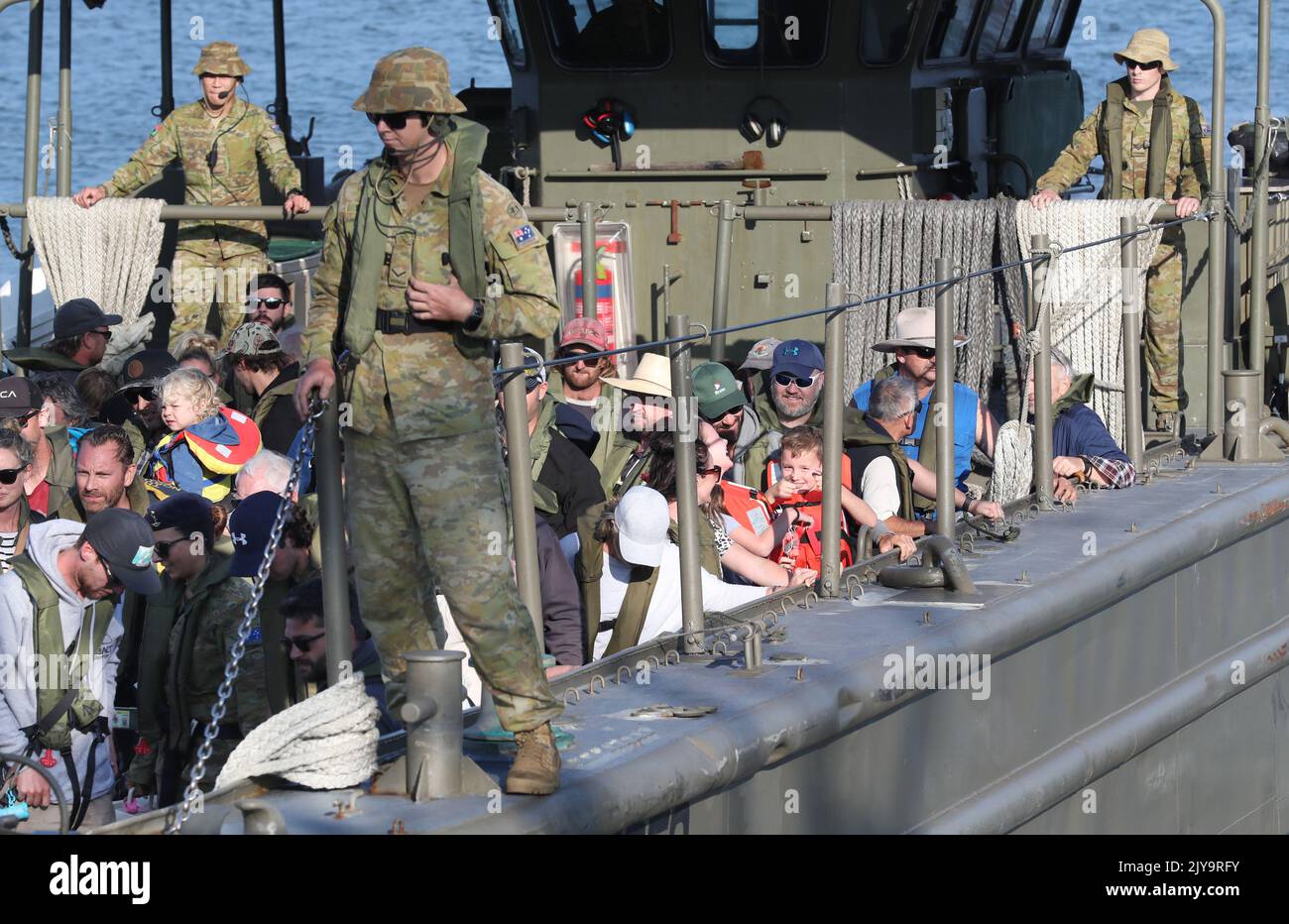 Evacuees from HMAS Choules are brought to shore on landing crafts in ...