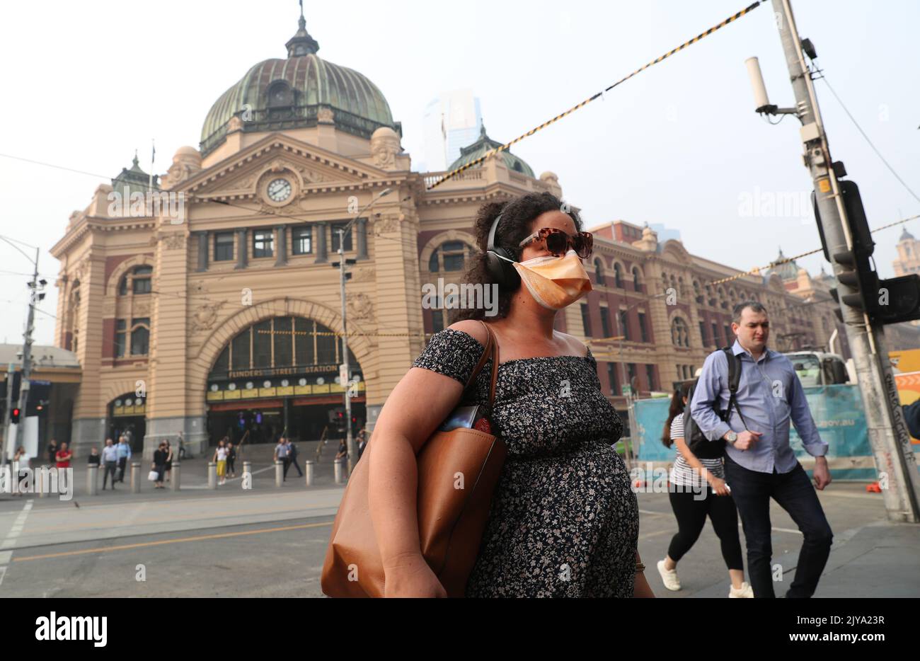 People wear breathing masks to protect themselves from a thick smoke ...