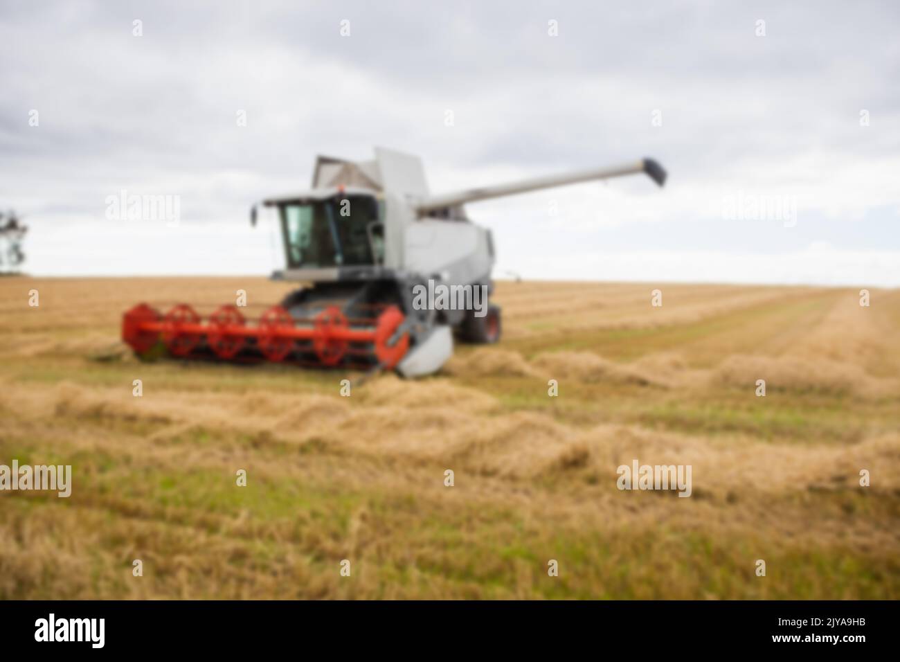 Defocused image combine harvester on field against cloudy sky Stock ...