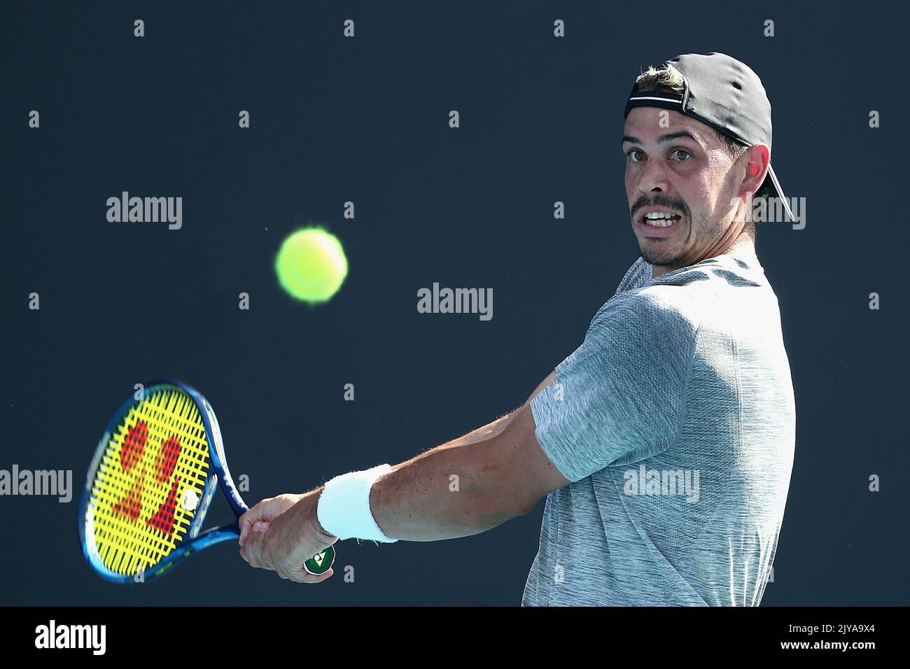 Alex Bolt of Australia plays a backhand in his singles match against ...