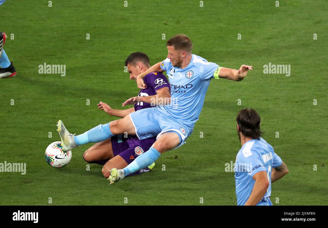 Craig Noone of Melbourne City fouls Joel Chianese of Perth Glory and ...