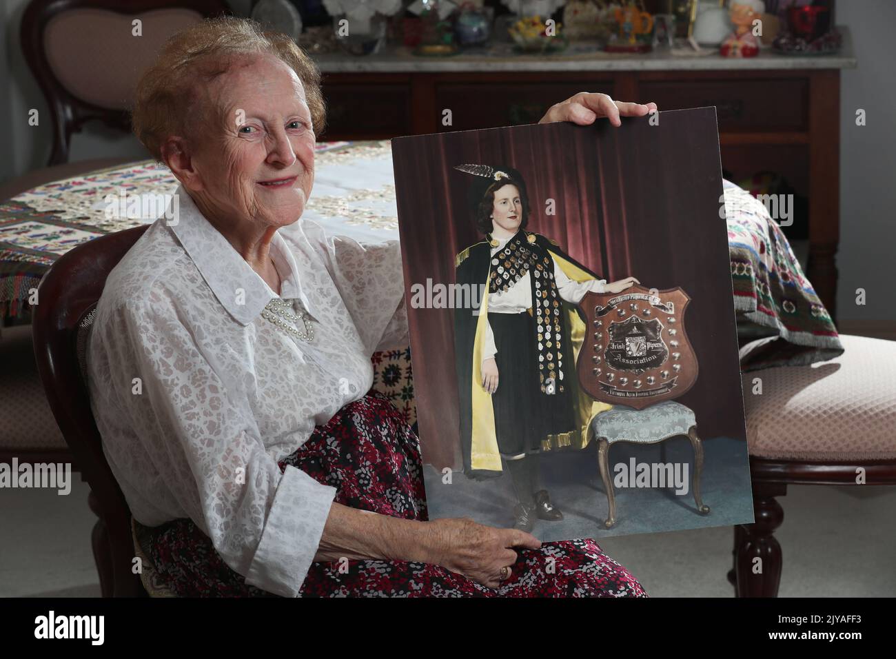 Geraldine Ryan, 89, poses for a photograph holding a portrait of ...